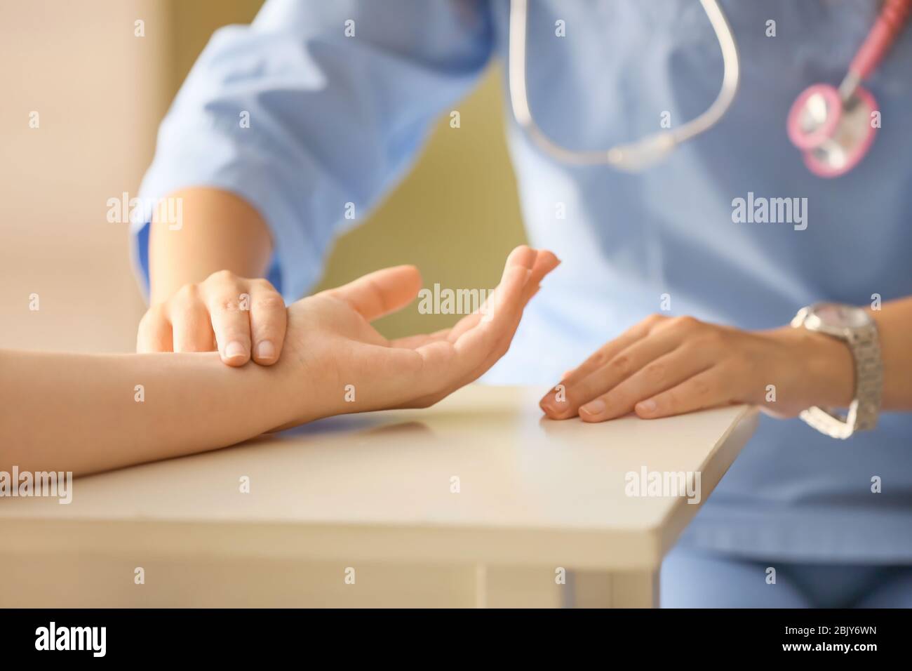 Doctor measuring pulse of young woman in clinic Stock Photo - Alamy