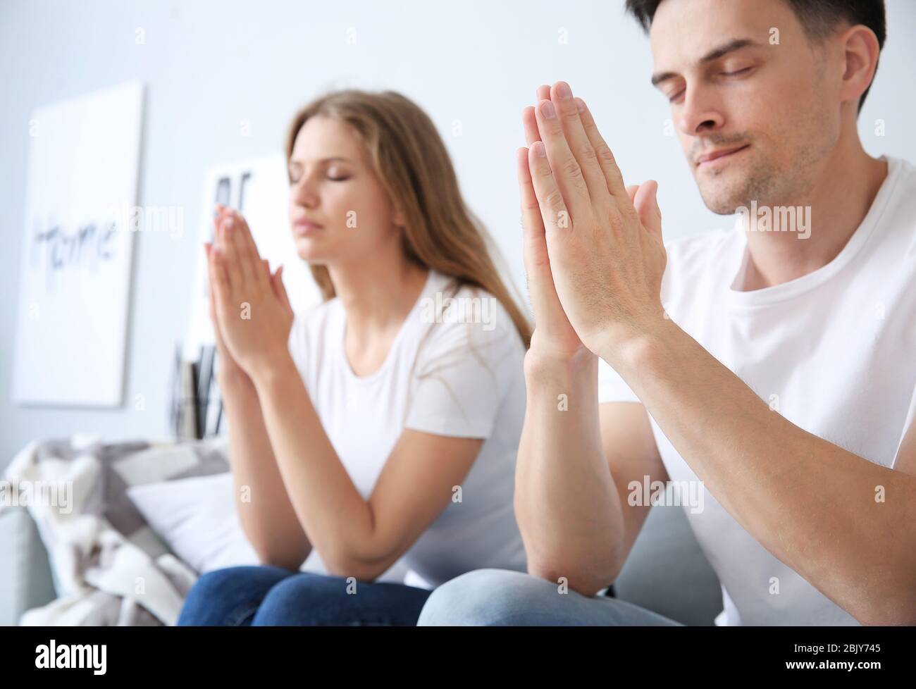 Religious couple praying to God at home Stock Photo - Alamy