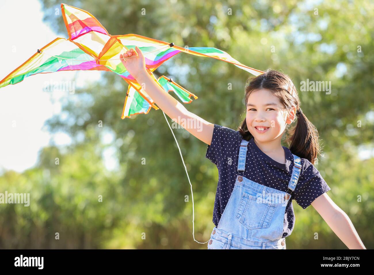 Little girl flying kite outdoors Stock Photo - Alamy