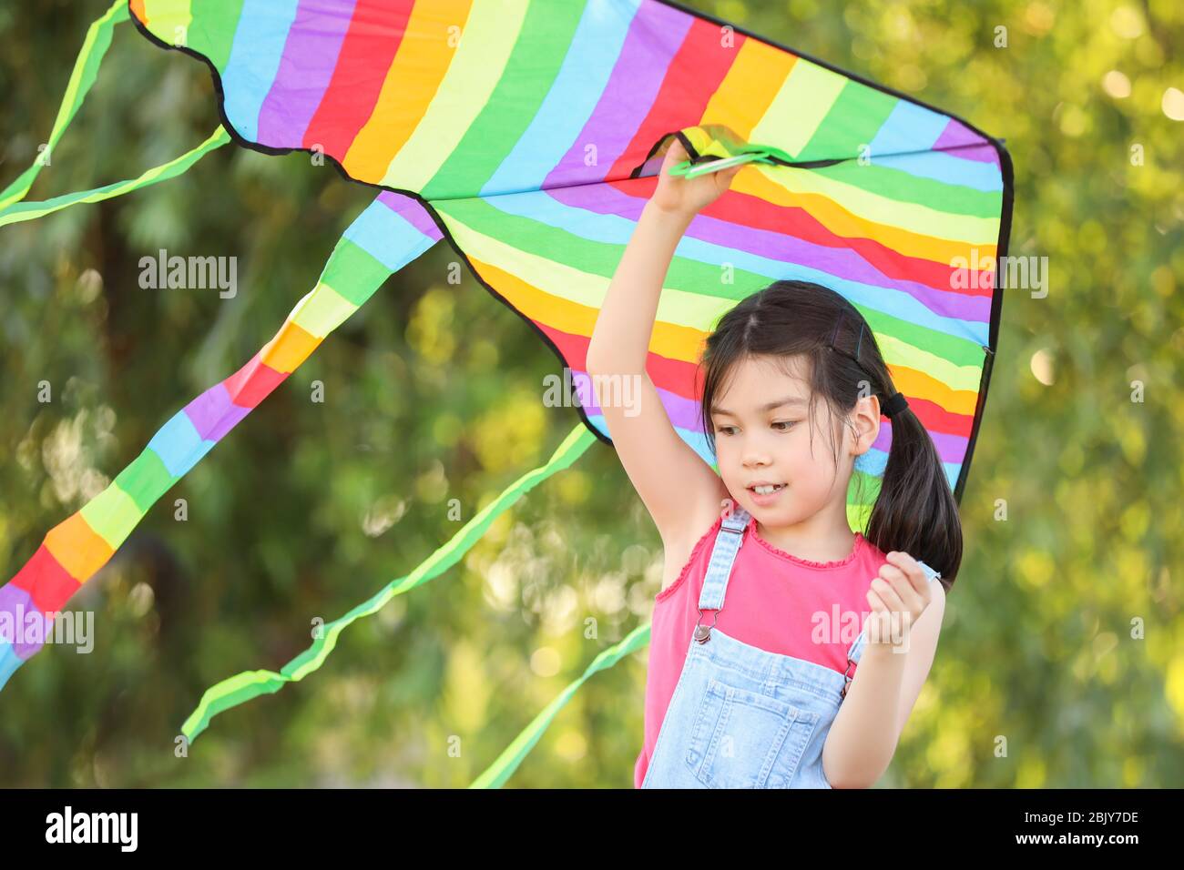 Little girl flying kite outdoors Stock Photo - Alamy