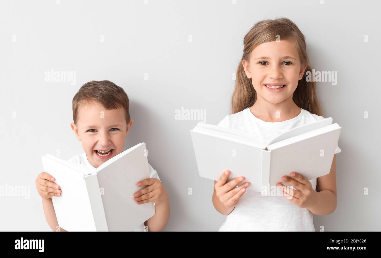 Little children with books on light background Stock Photo - Alamy