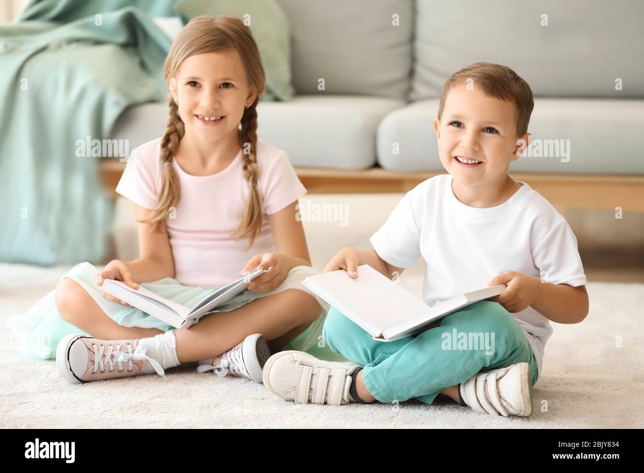 Cute little children reading books at home Stock Photo - Alamy