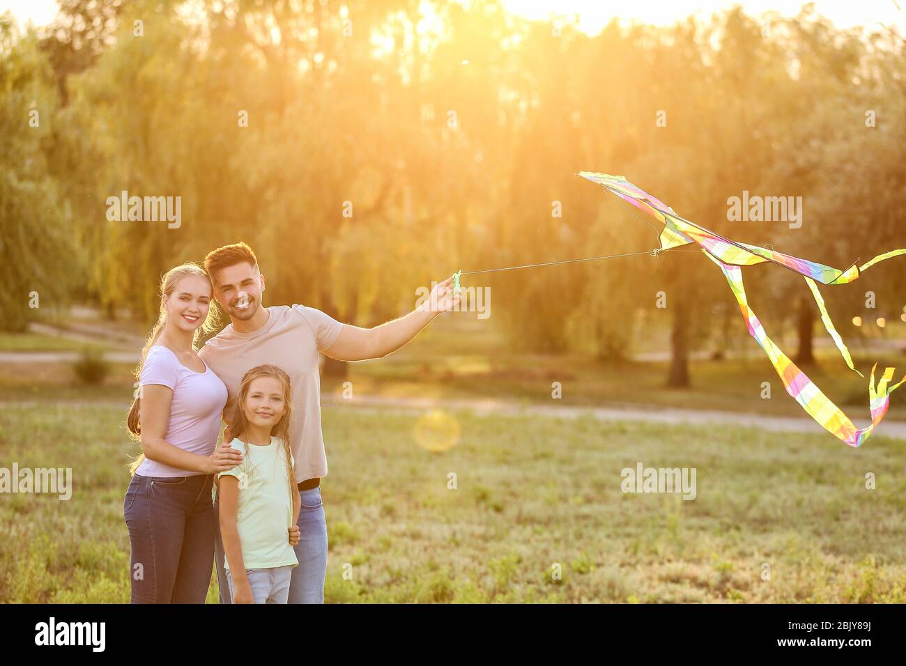 Happy family flying kite outdoors Stock Photo - Alamy