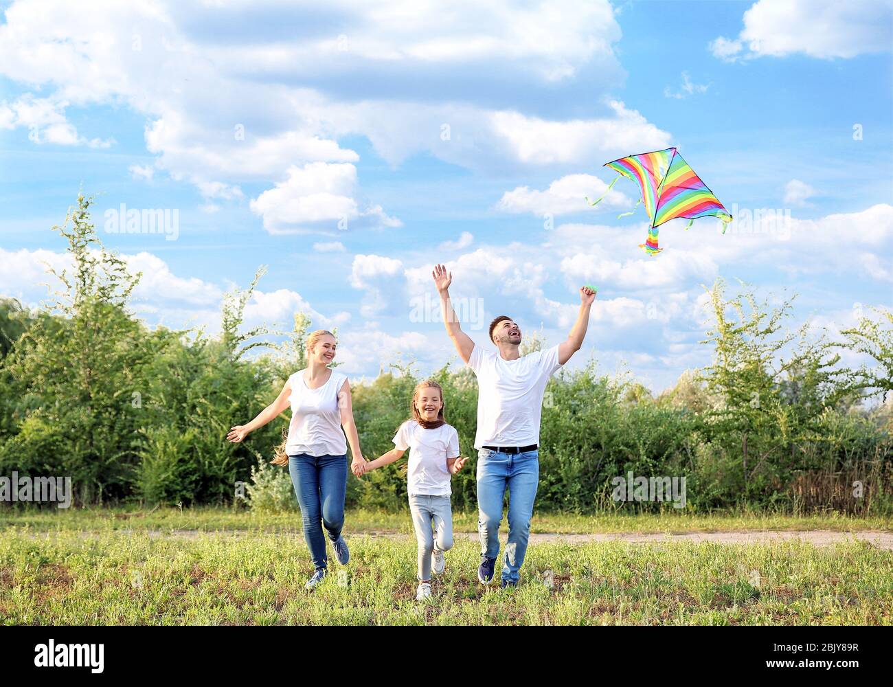 Happy family flying kite outdoors Stock Photo - Alamy