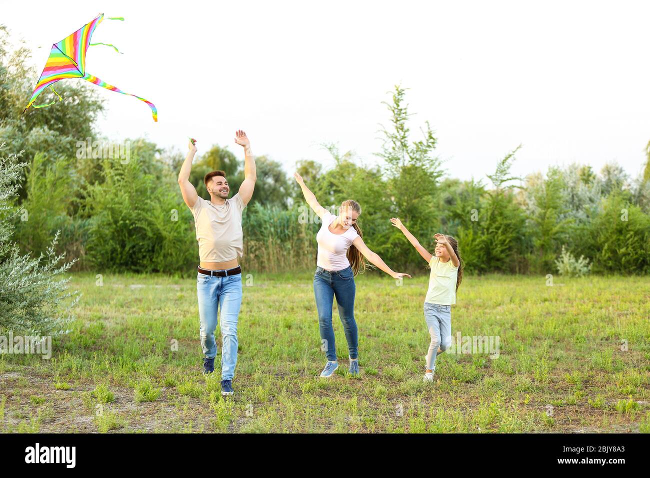 Happy family flying kite outdoors Stock Photo - Alamy