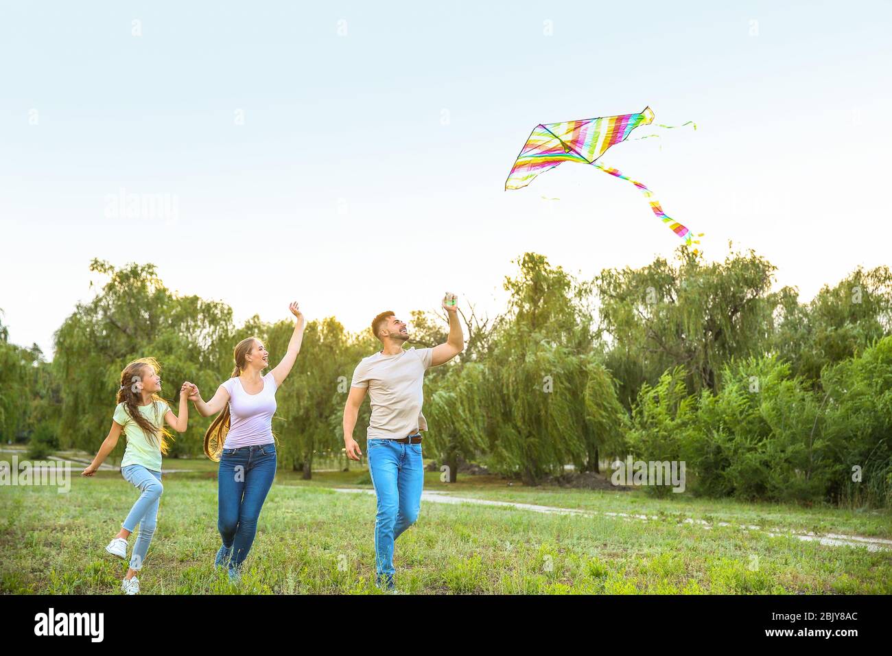 Happy family flying kite outdoors Stock Photo - Alamy