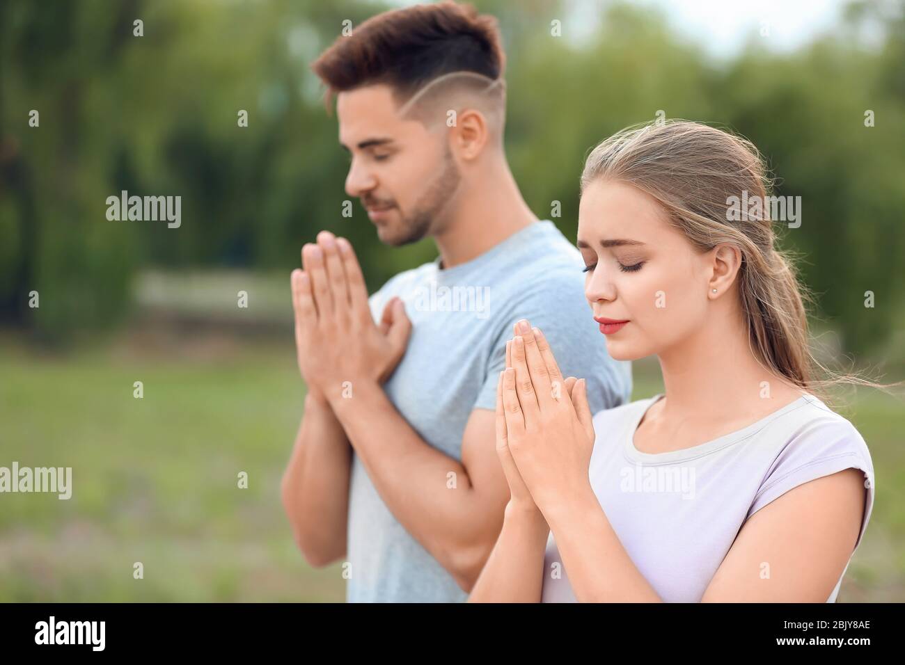 Young couple praying to God outdoors Stock Photo - Alamy