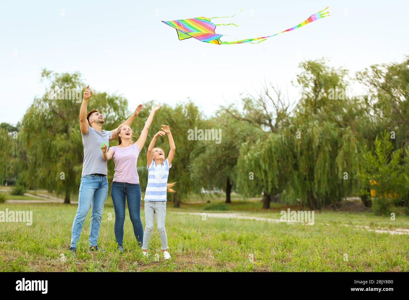 Happy family flying kite outdoors Stock Photo - Alamy