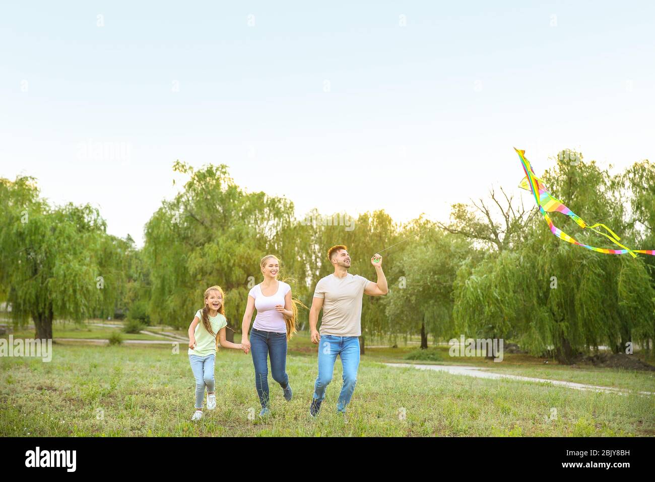 Happy family flying kite outdoors Stock Photo - Alamy