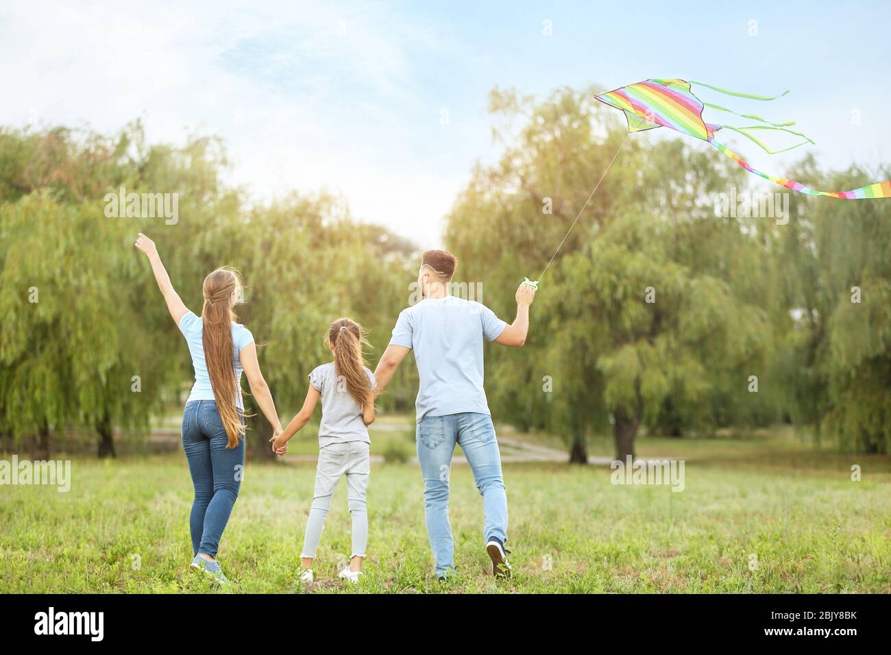 Happy family flying kite outdoors Stock Photo - Alamy