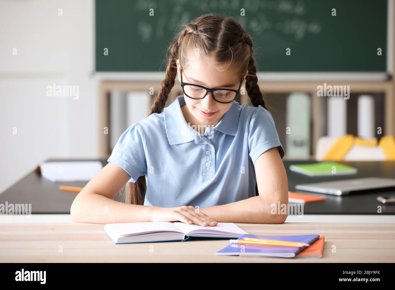Cute little girl during lesson in classroom Stock Photo - Alamy