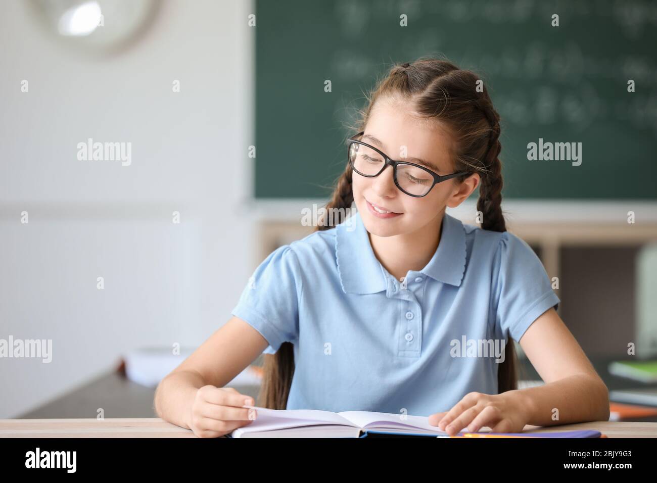 Cute little girl during lesson in classroom Stock Photo - Alamy