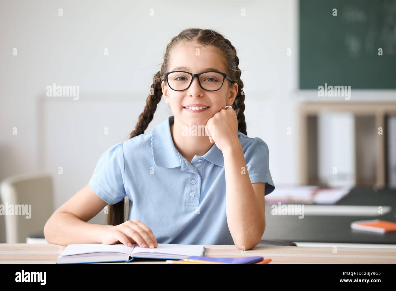Cute little girl during lesson in classroom Stock Photo - Alamy