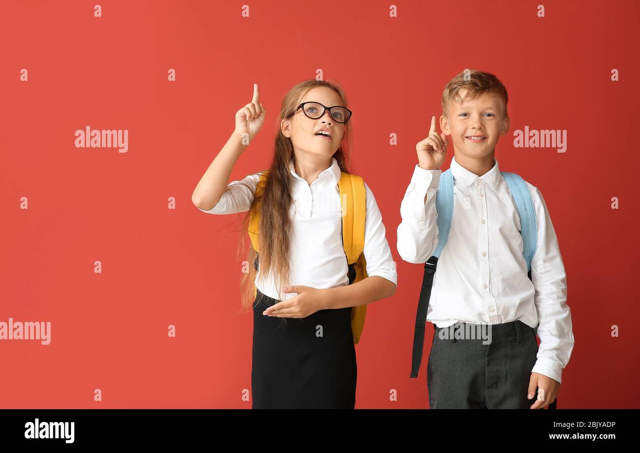 Little pupils with raised index fingers on color background Stock Photo ...
