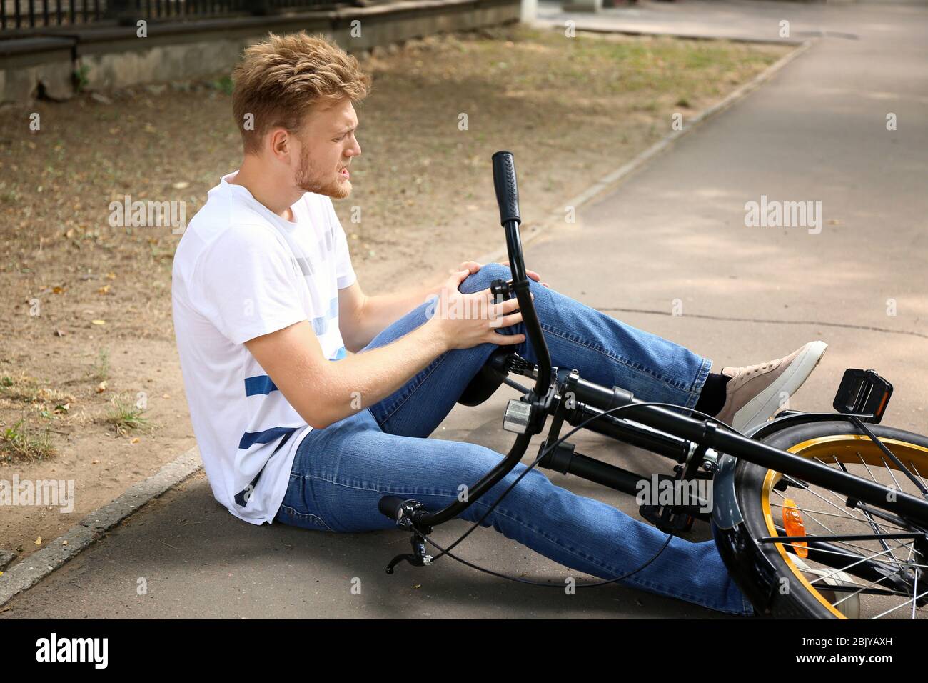 Young man fallen off his bicycle outdoors Stock Photo - Alamy