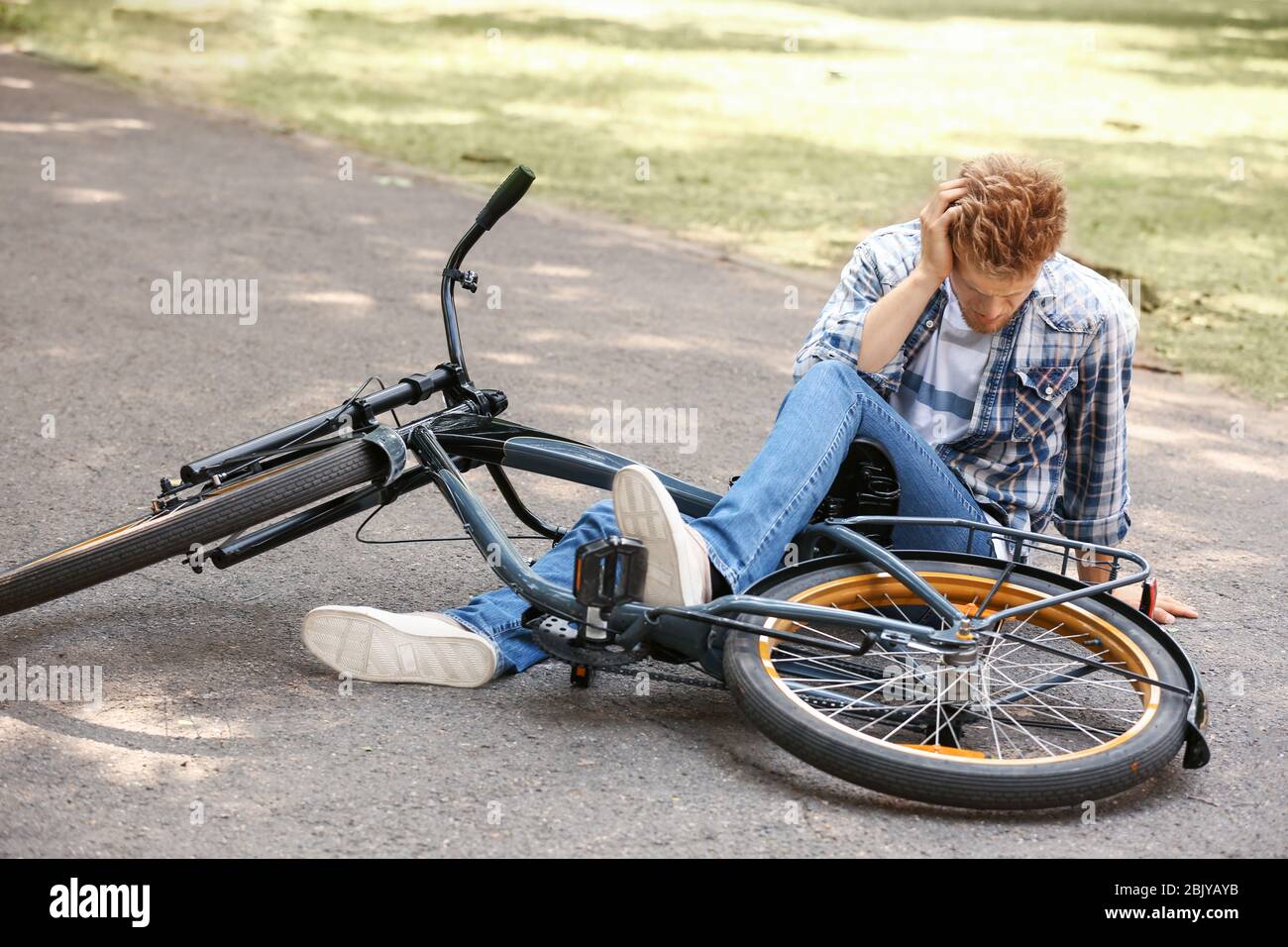 Young man fallen off his bicycle outdoors Stock Photo - Alamy