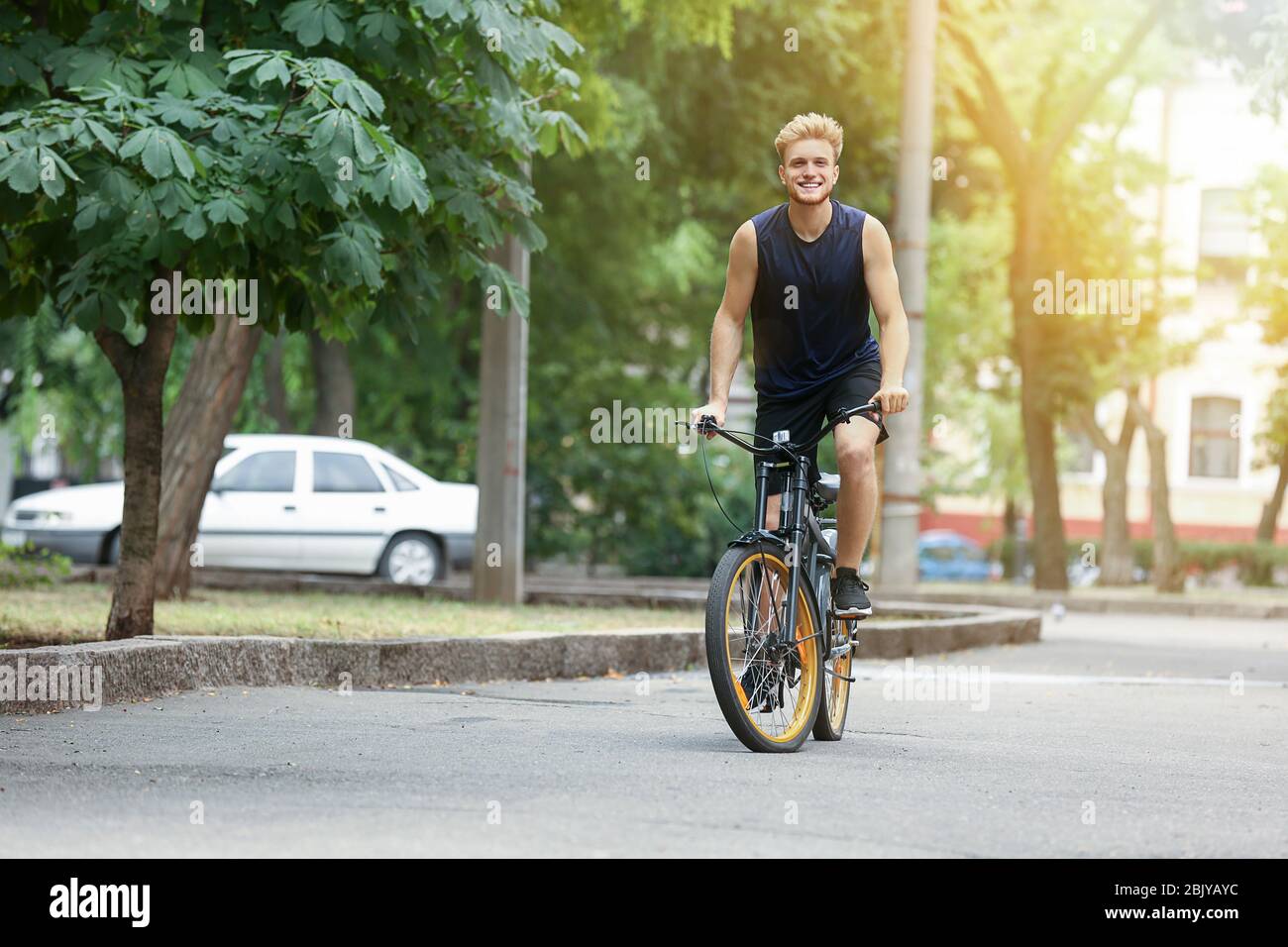 Sporty young man riding bicycle outdoors Stock Photo - Alamy