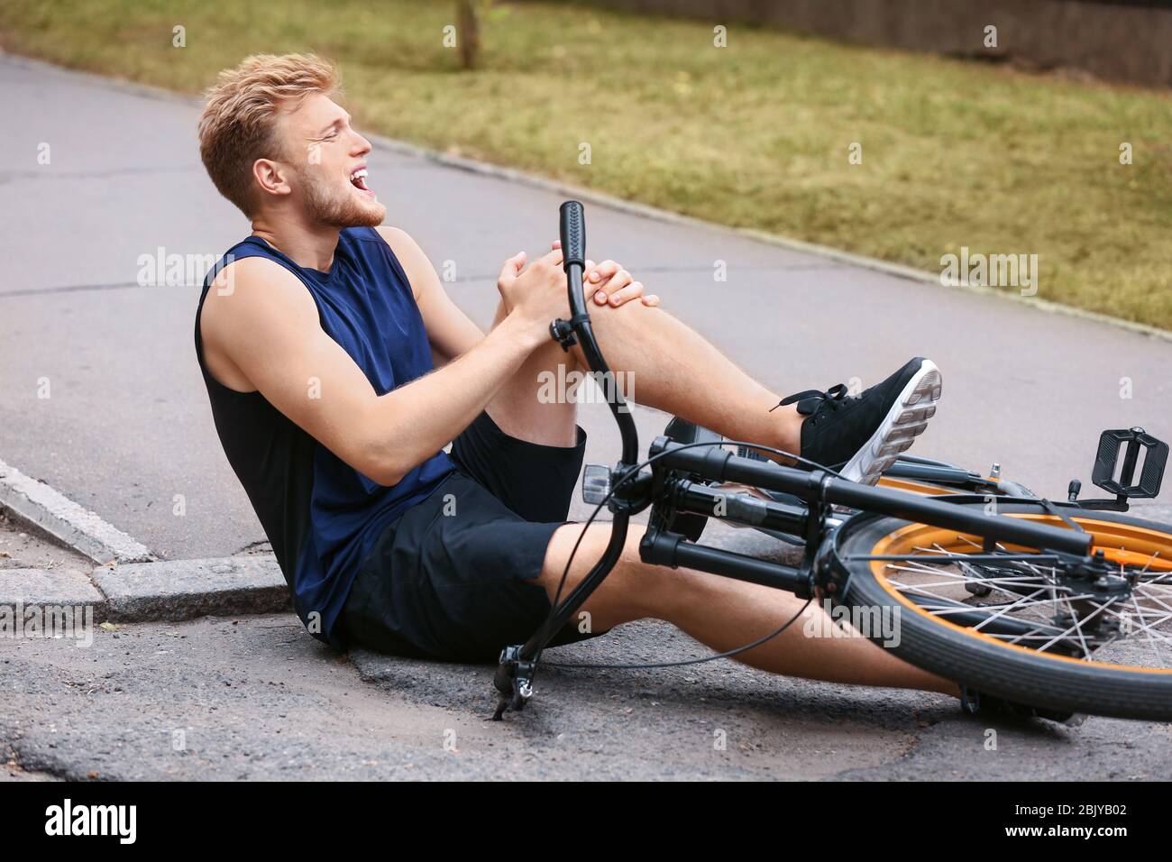 Sporty young man fallen off his bicycle outdoors Stock Photo - Alamy