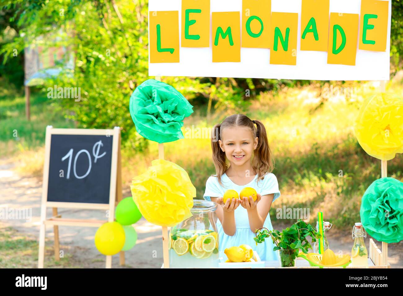 Cute little girl at lemonade stand in park Stock Photo - Alamy