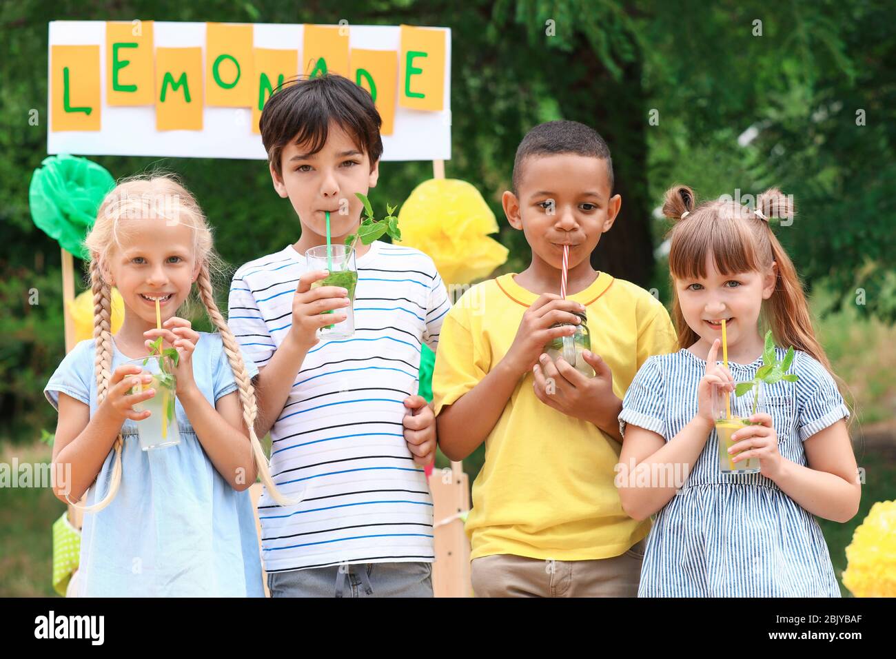 Cute little children drinking lemonade in park Stock Photo - Alamy
