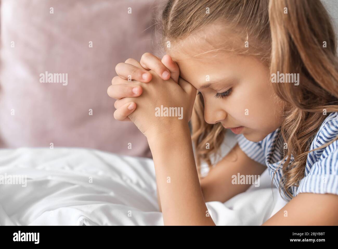 Cute little girl praying in bedroom Stock Photo - Alamy