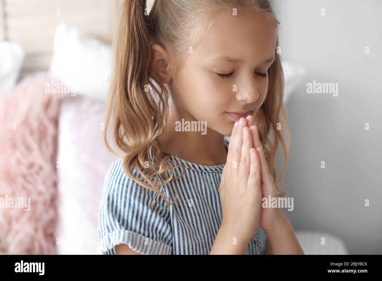 Cute little girl praying in bedroom Stock Photo - Alamy