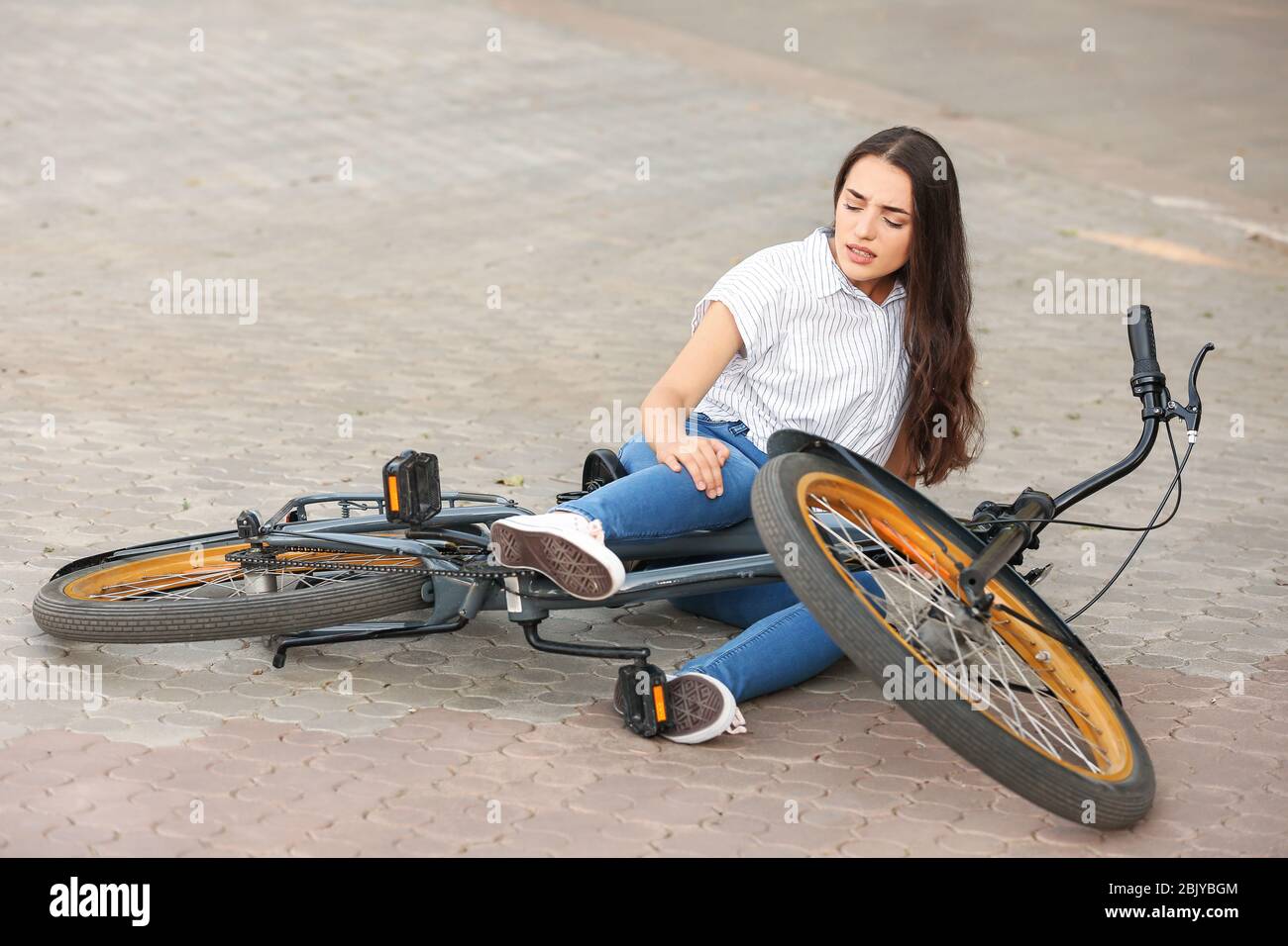 Young woman fallen off her bicycle outdoors Stock Photo - Alamy