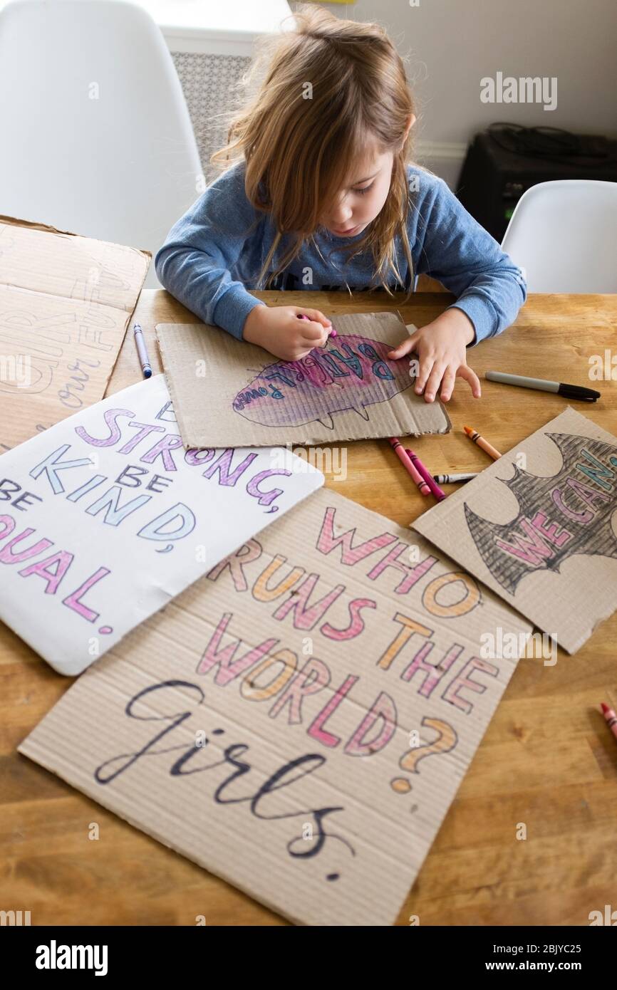 Girl coloring protest signs for women's march Stock Photo - Alamy