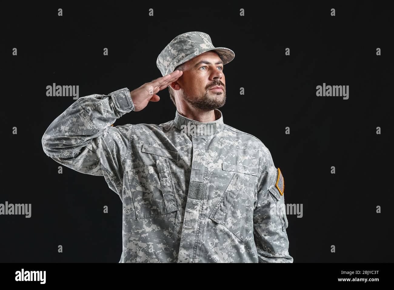 Saluting soldier on dark background Stock Photo - Alamy