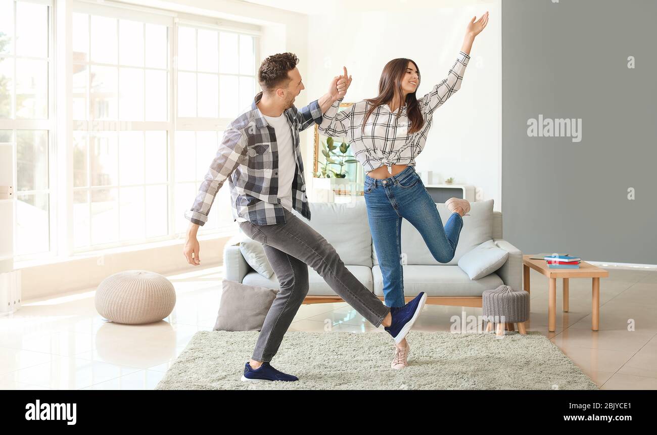 Happy young couple dancing at home Stock Photo - Alamy