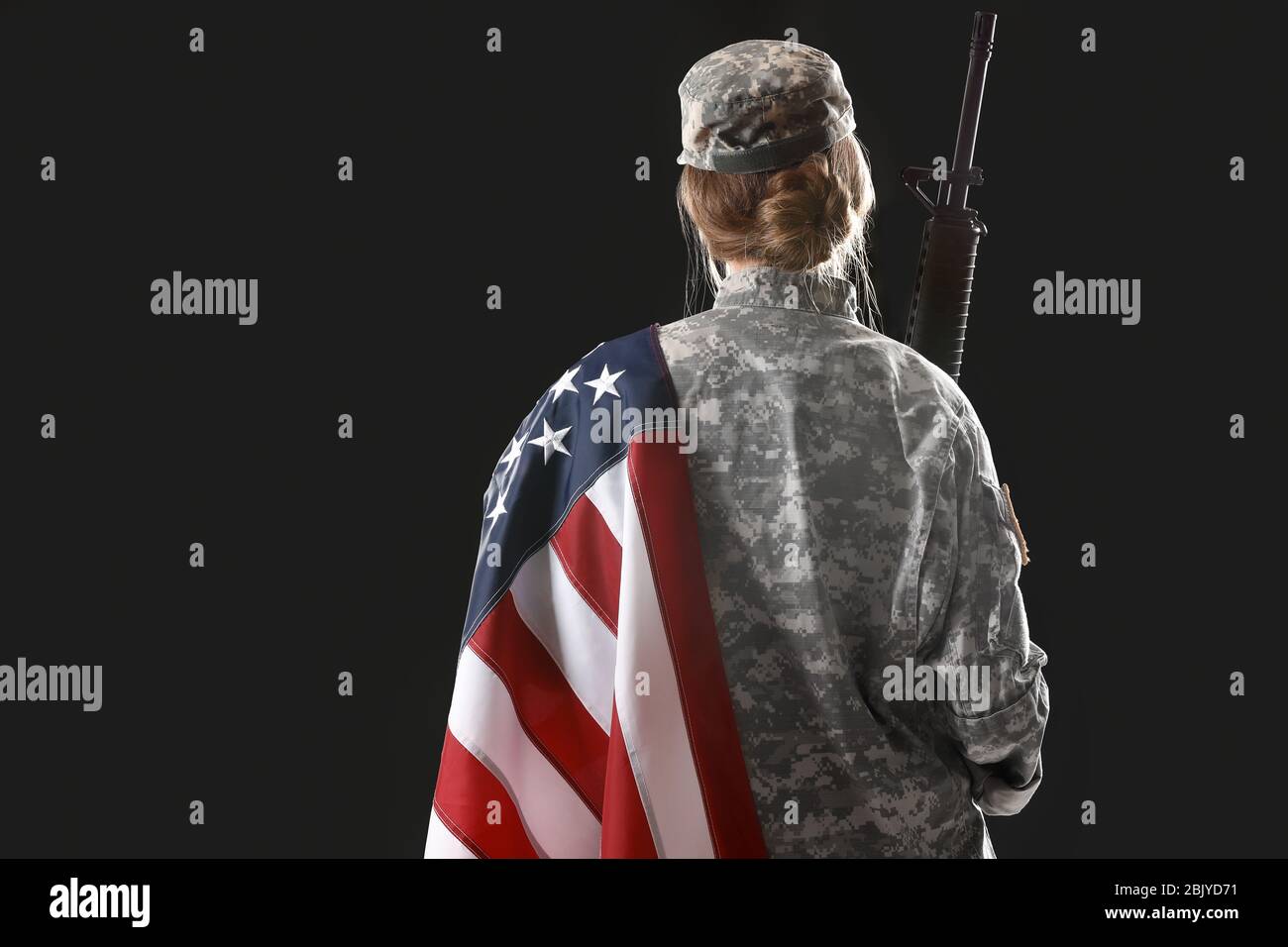 Young female soldier with USA flag on dark background, back view Stock ...