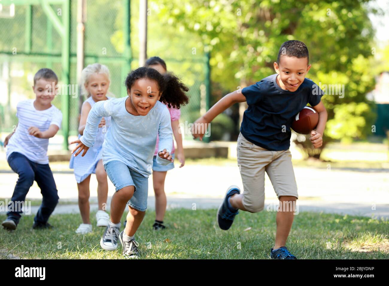 Cute little children playing with rugby ball in park Stock Photo - Alamy