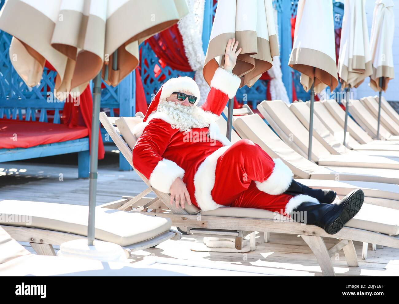 Cool Santa Claus resting on sun lounger at resort Stock Photo - Alamy