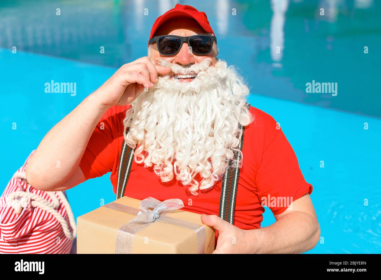 Santa Claus with gifts near swimming pool at resort Stock Photo - Alamy