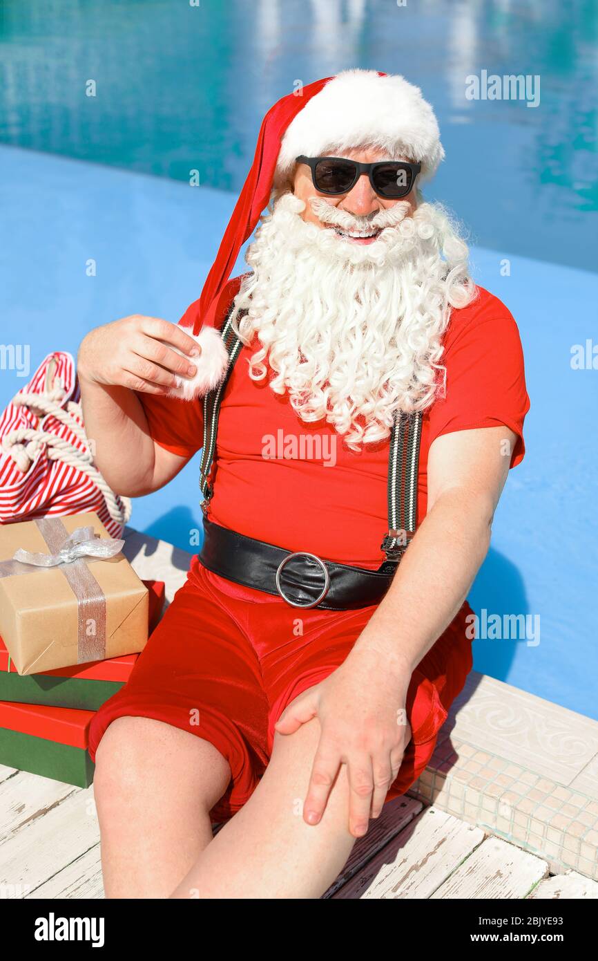 Santa Claus with gifts near swimming pool at resort Stock Photo - Alamy