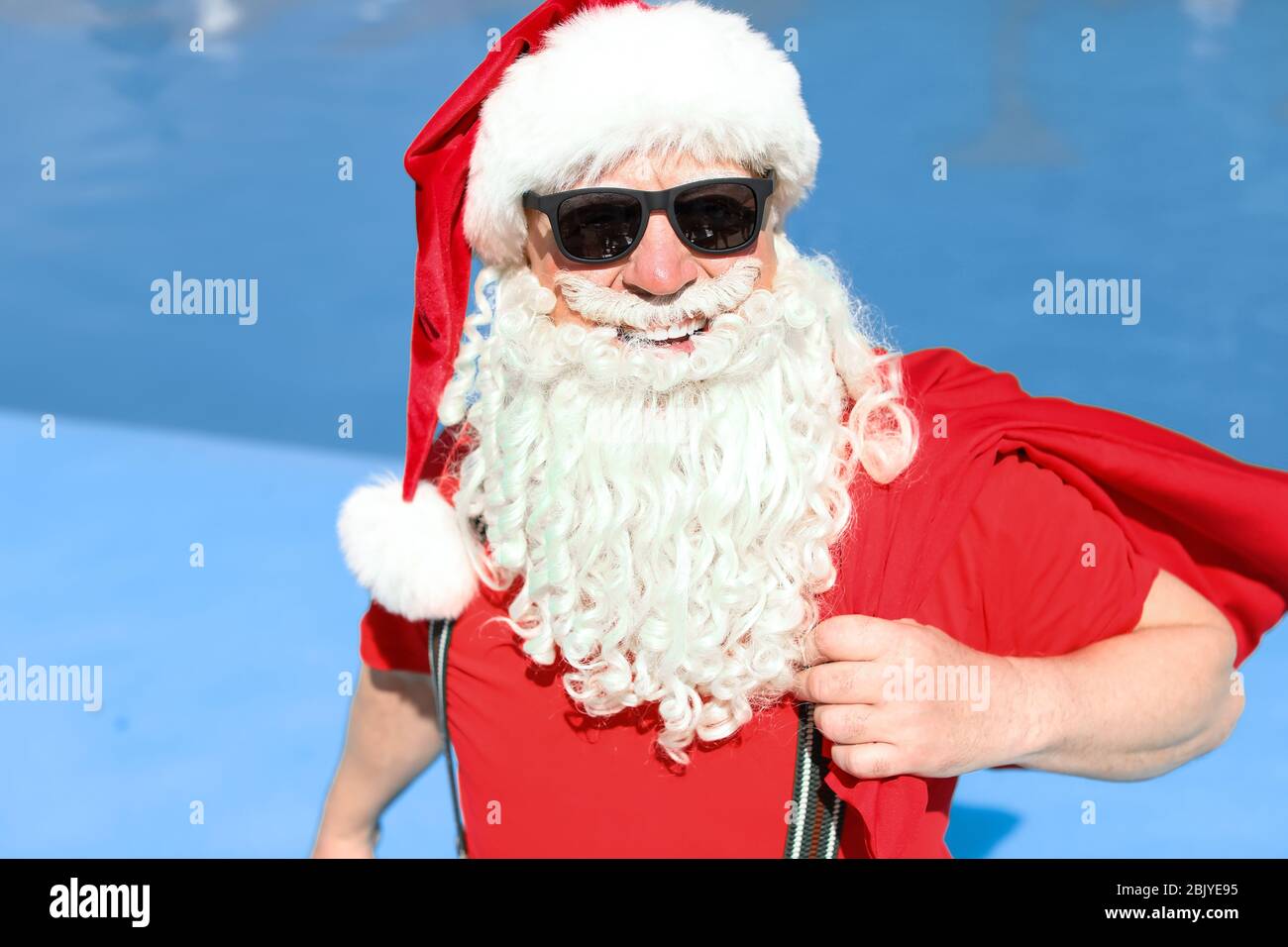 Cool Santa Claus near swimming pool at resort Stock Photo - Alamy