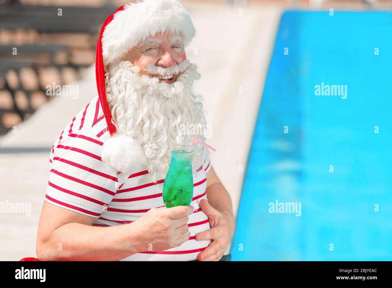 Santa Claus with cocktail near swimming pool at resort Stock Photo - Alamy