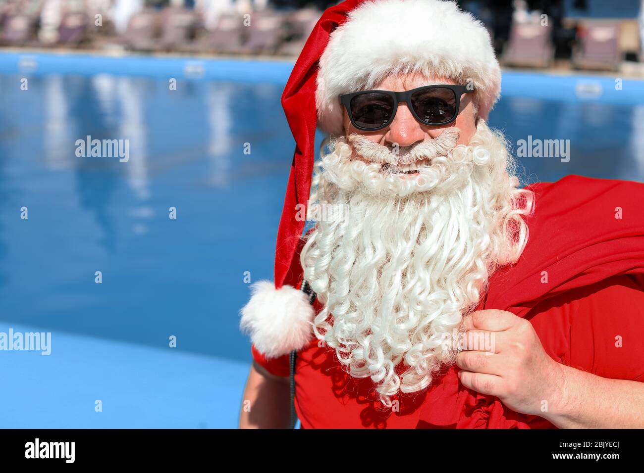 Cool Santa Claus near swimming pool at resort Stock Photo - Alamy