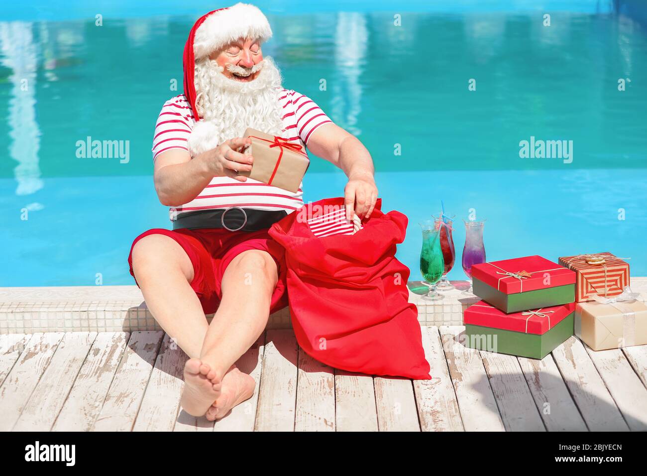 Santa Claus with gifts near swimming pool at resort Stock Photo - Alamy