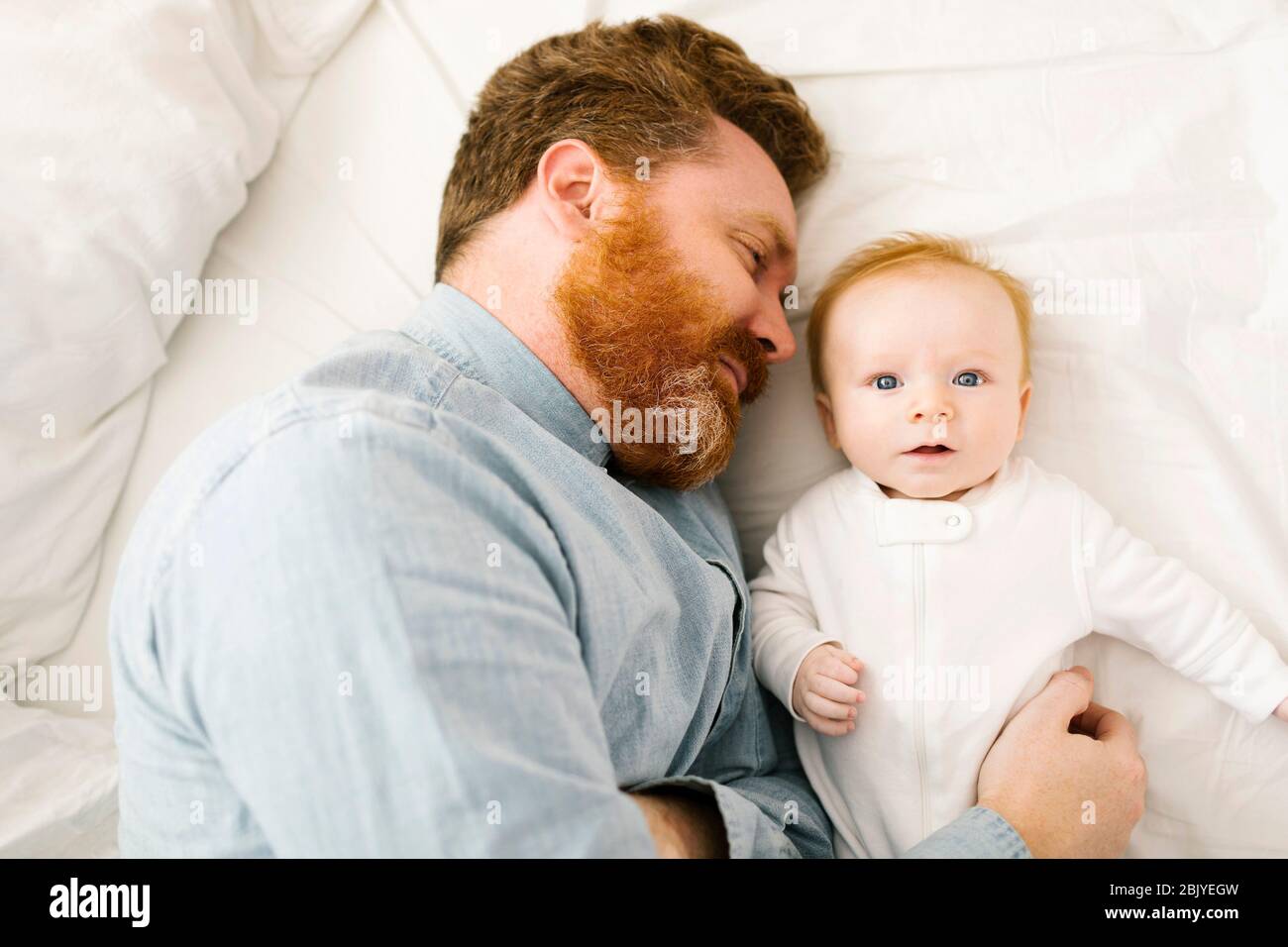 Father and baby boy (2-3 months) lying on bed Stock Photo - Alamy