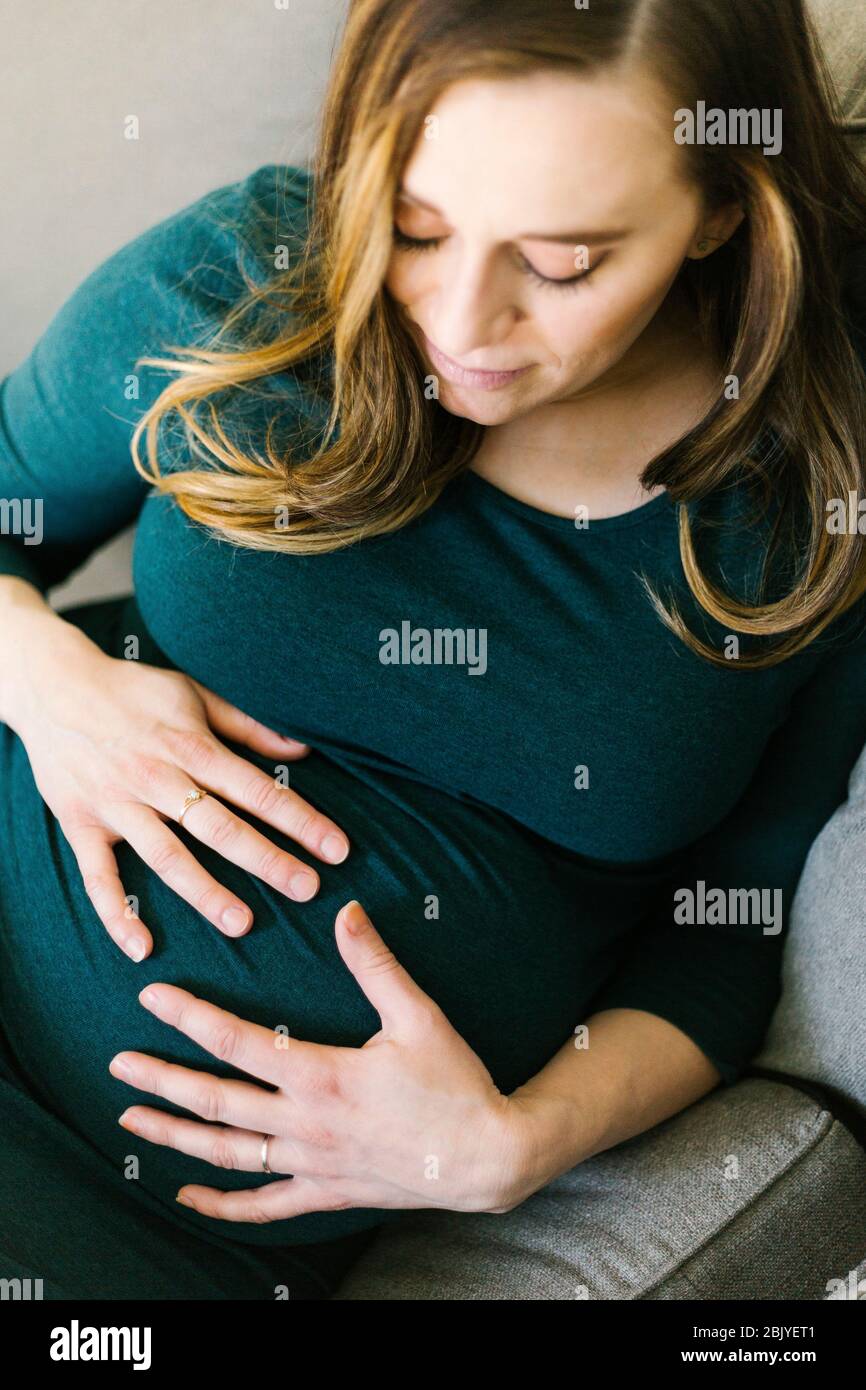 Pregnant woman touching belly Stock Photo - Alamy