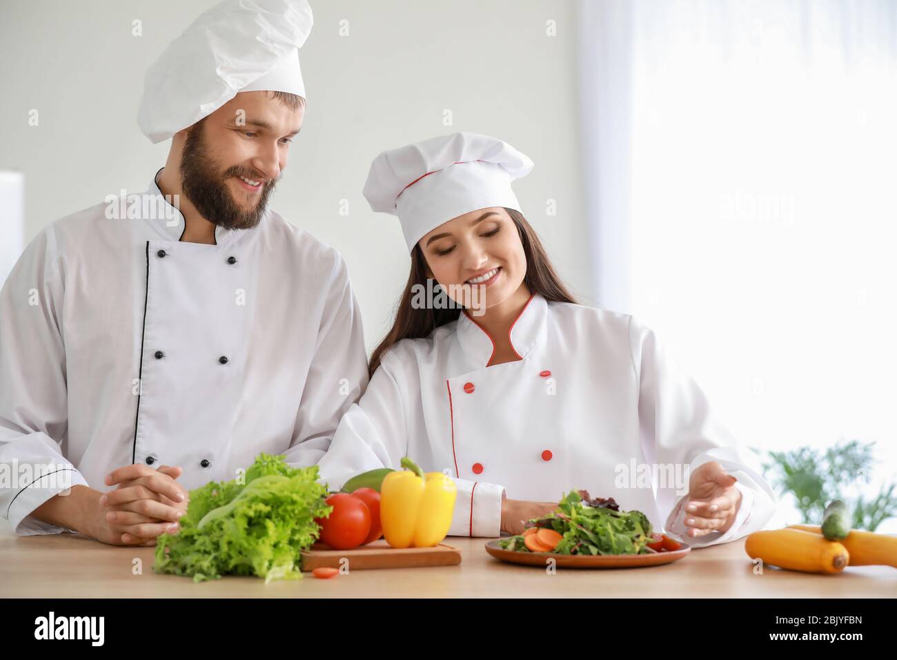 Professional chefs preparing vegetable salad in kitchen Stock Photo - Alamy