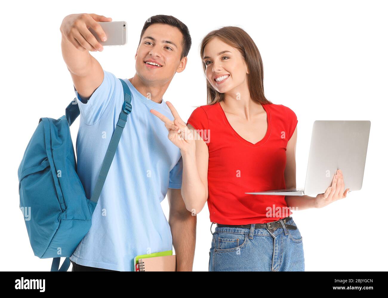 Portrait of young students with laptop taking selfie on white ...