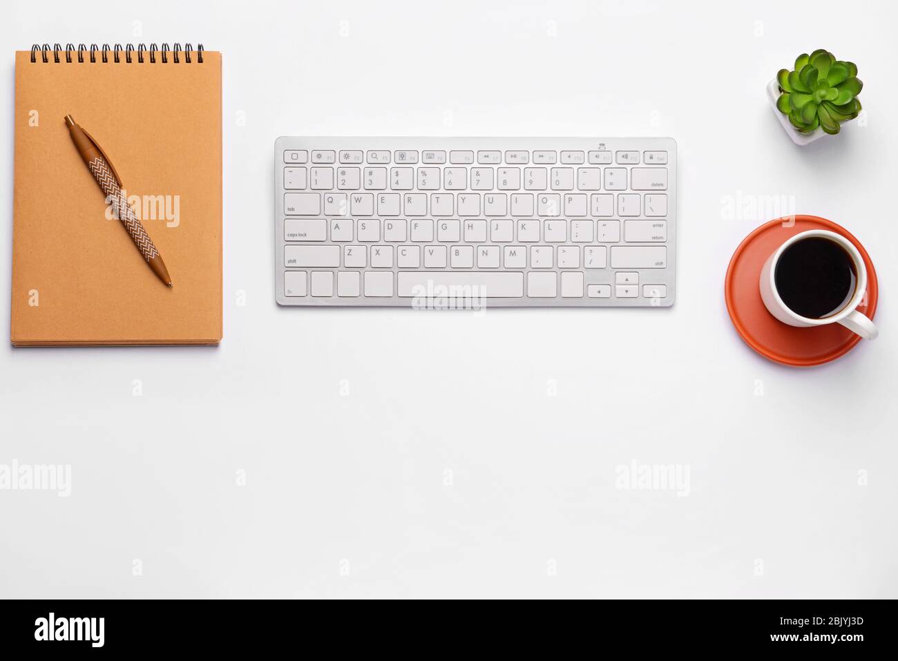 Modern computer keyboard with stationery and cup of coffee on white ...