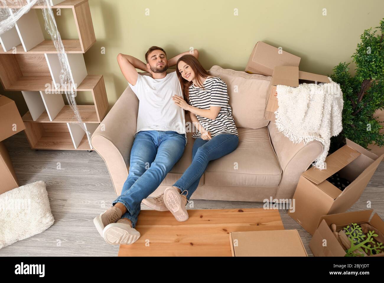 Young couple having break during moving into new house Stock Photo - Alamy