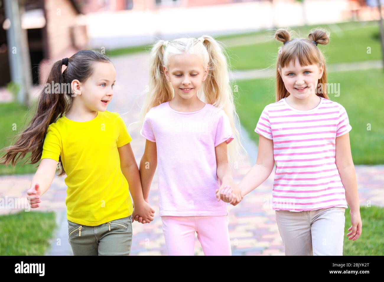 Cute little girls walking in park Stock Photo - Alamy
