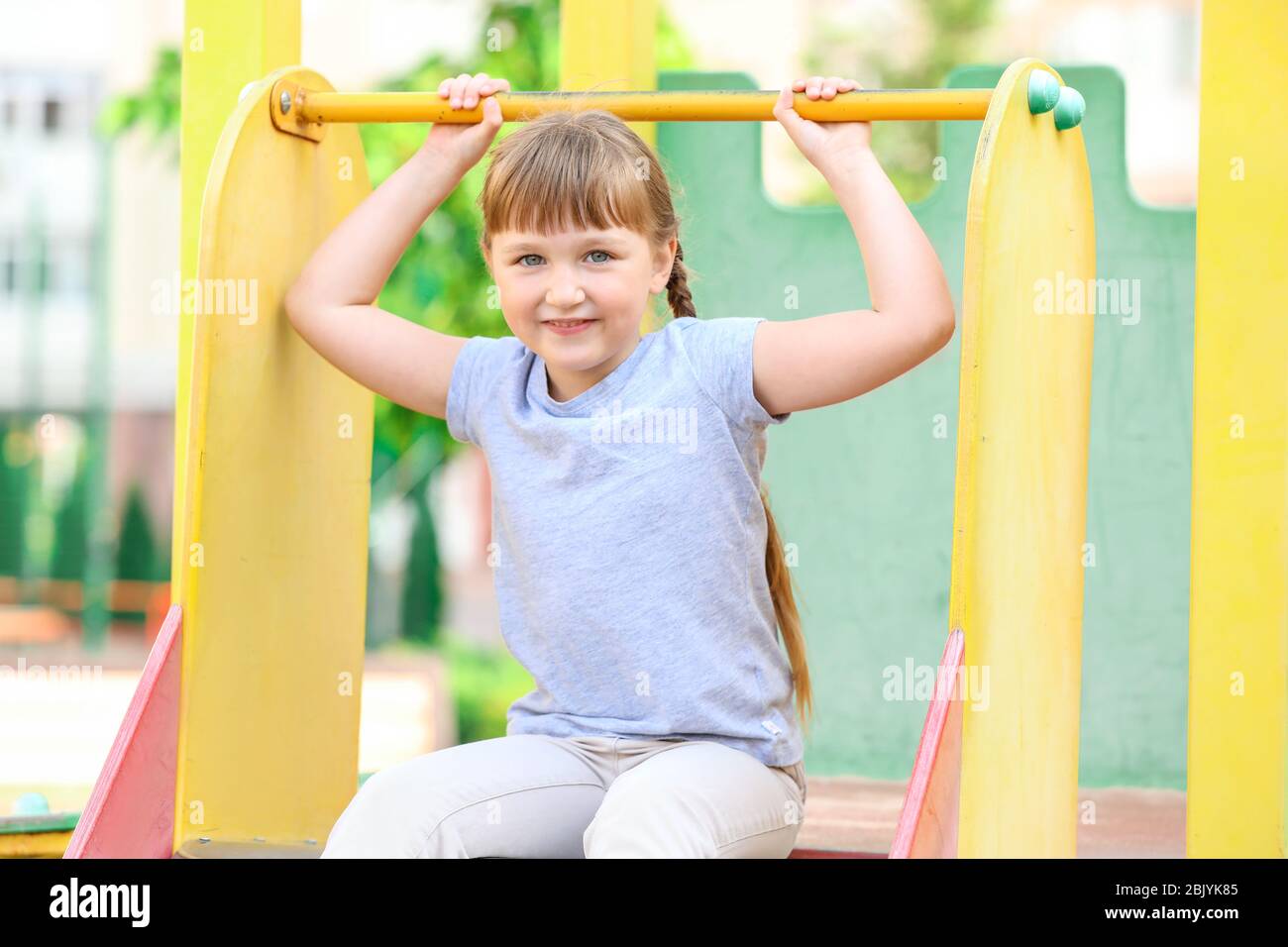 Cute little girl sliding on playground Stock Photo - Alamy