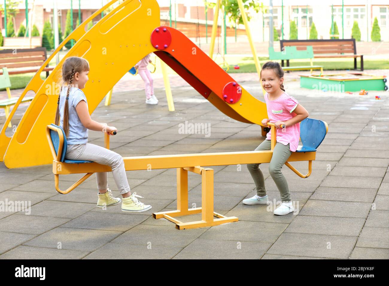 Cute little children on seesaw in park Stock Photo - Alamy