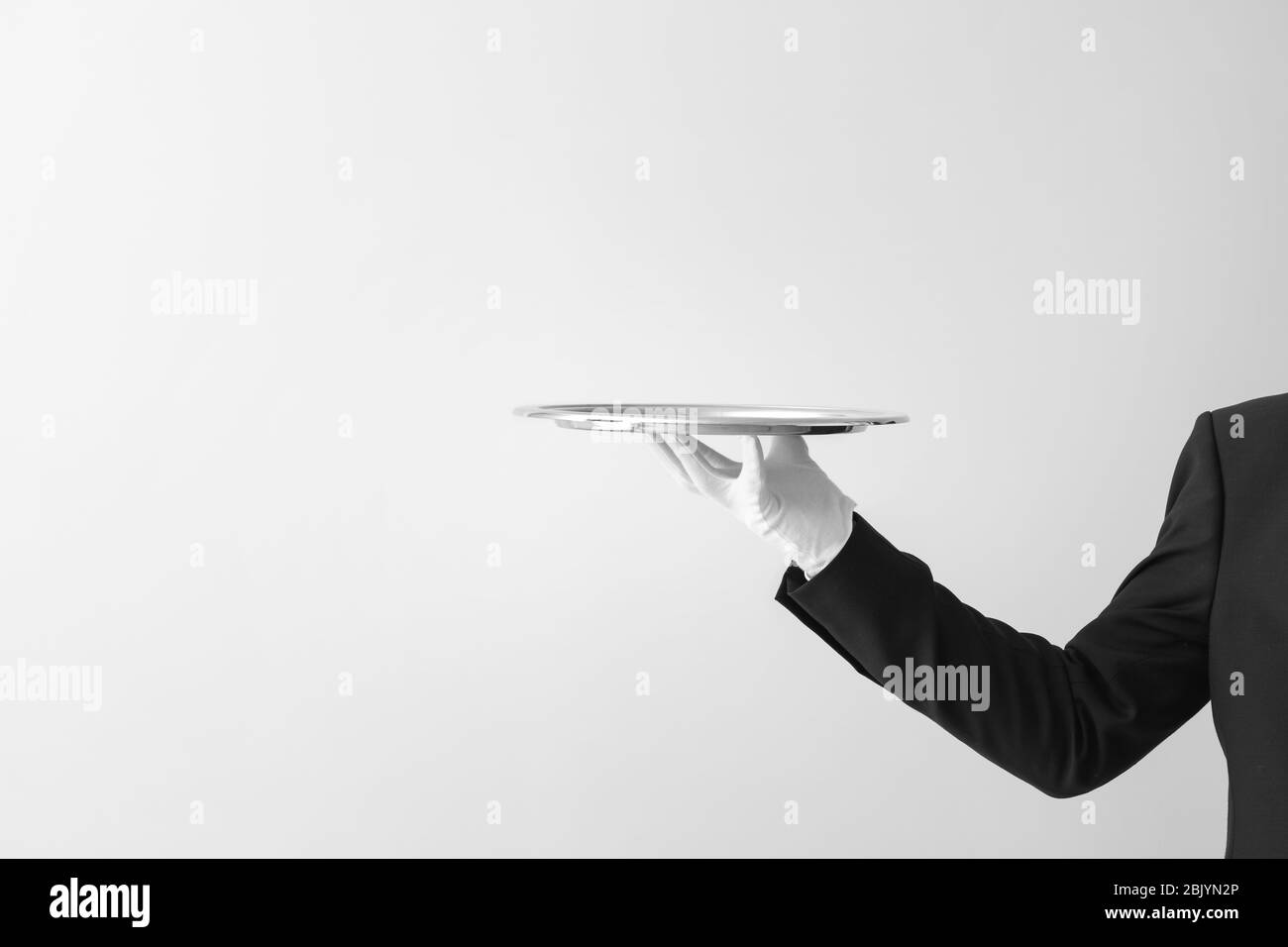 Hand of waiter with empty tray on light background Stock Photo - Alamy