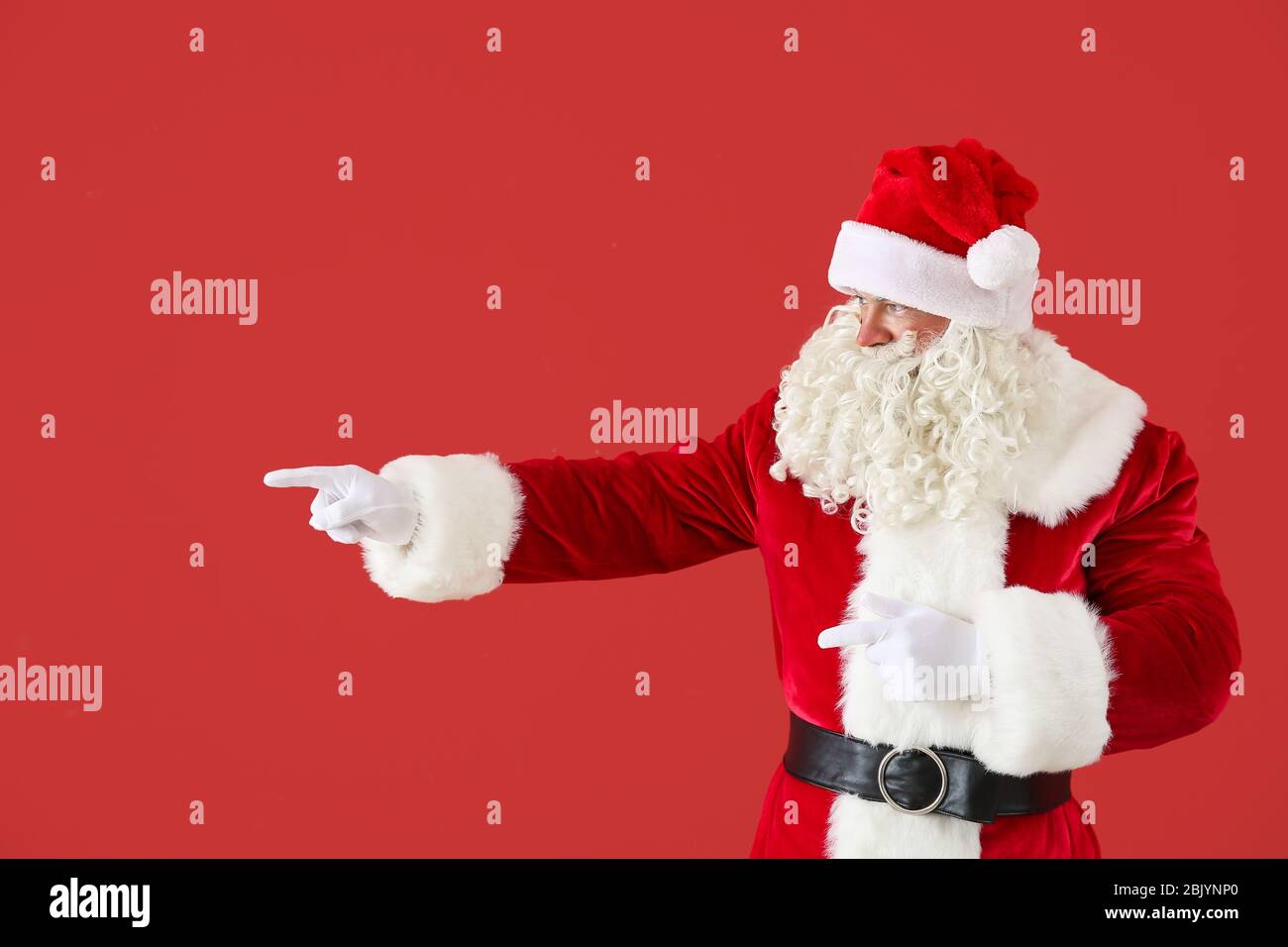 Portrait of Santa Claus pointing at something on color background Stock ...